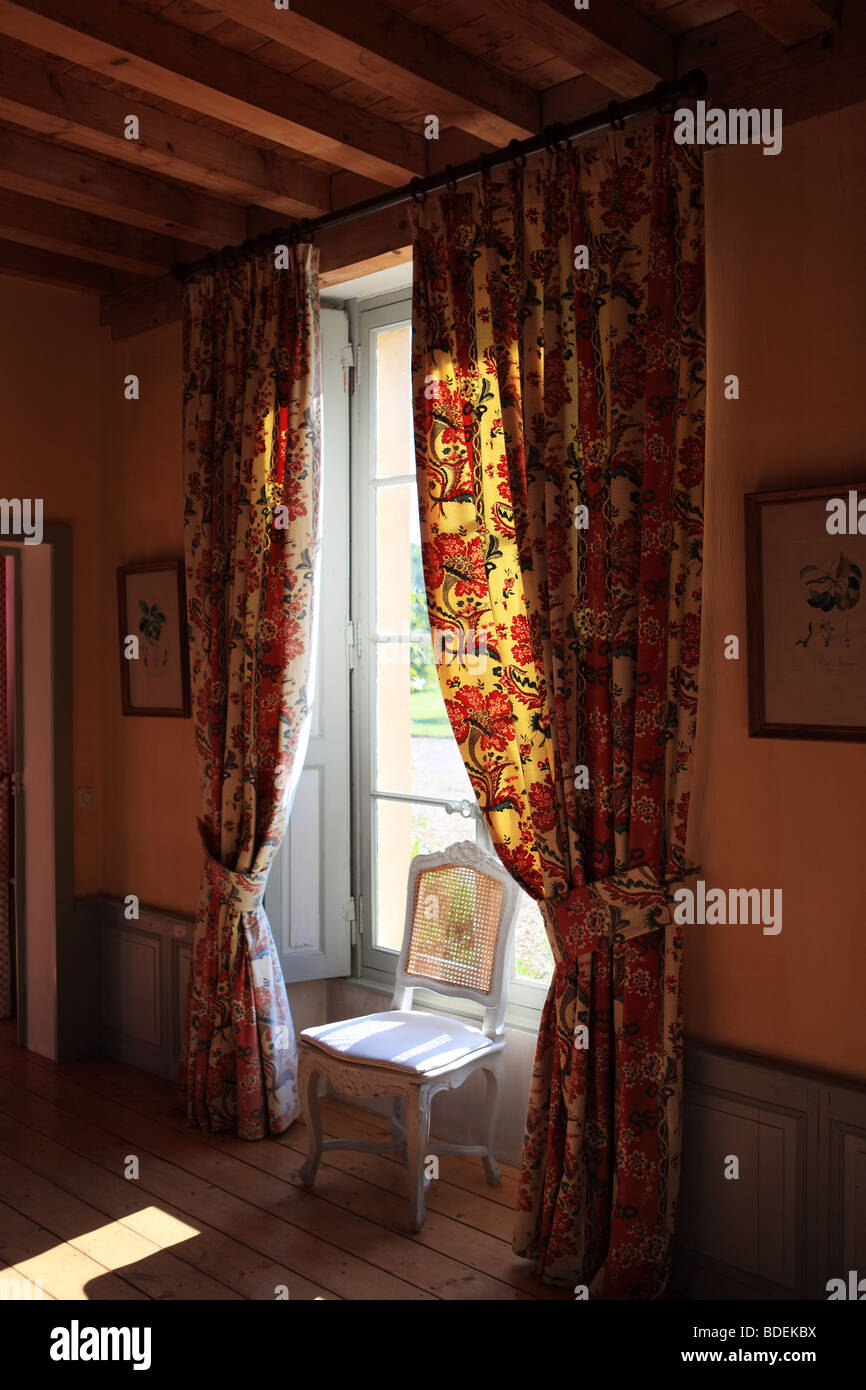 Chair beside window in living room Stock Photo - Alamy