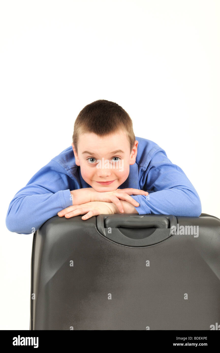 Portrait of young boy leaning on suitcase against white background ... Portrait of young boy leaning on suitcase against white background ...
