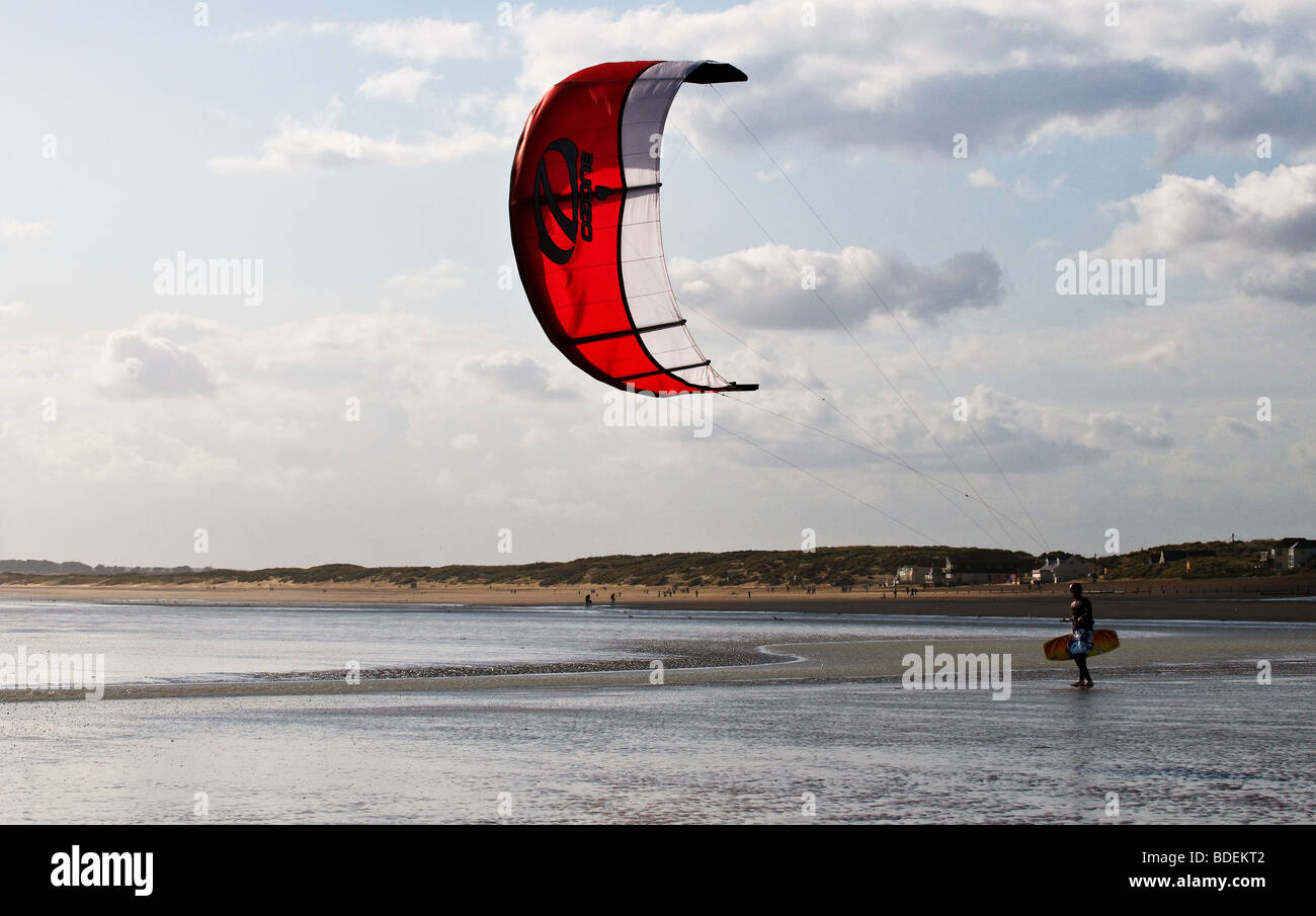A parasurfer walking across the beach at Camber Sands in Sussex. Photo ...