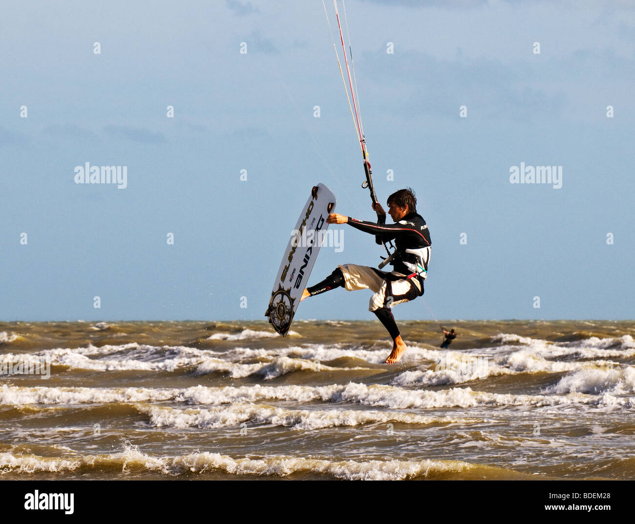 A parasurfer performing an acrobatic jump in the sea off Camber Sands ...