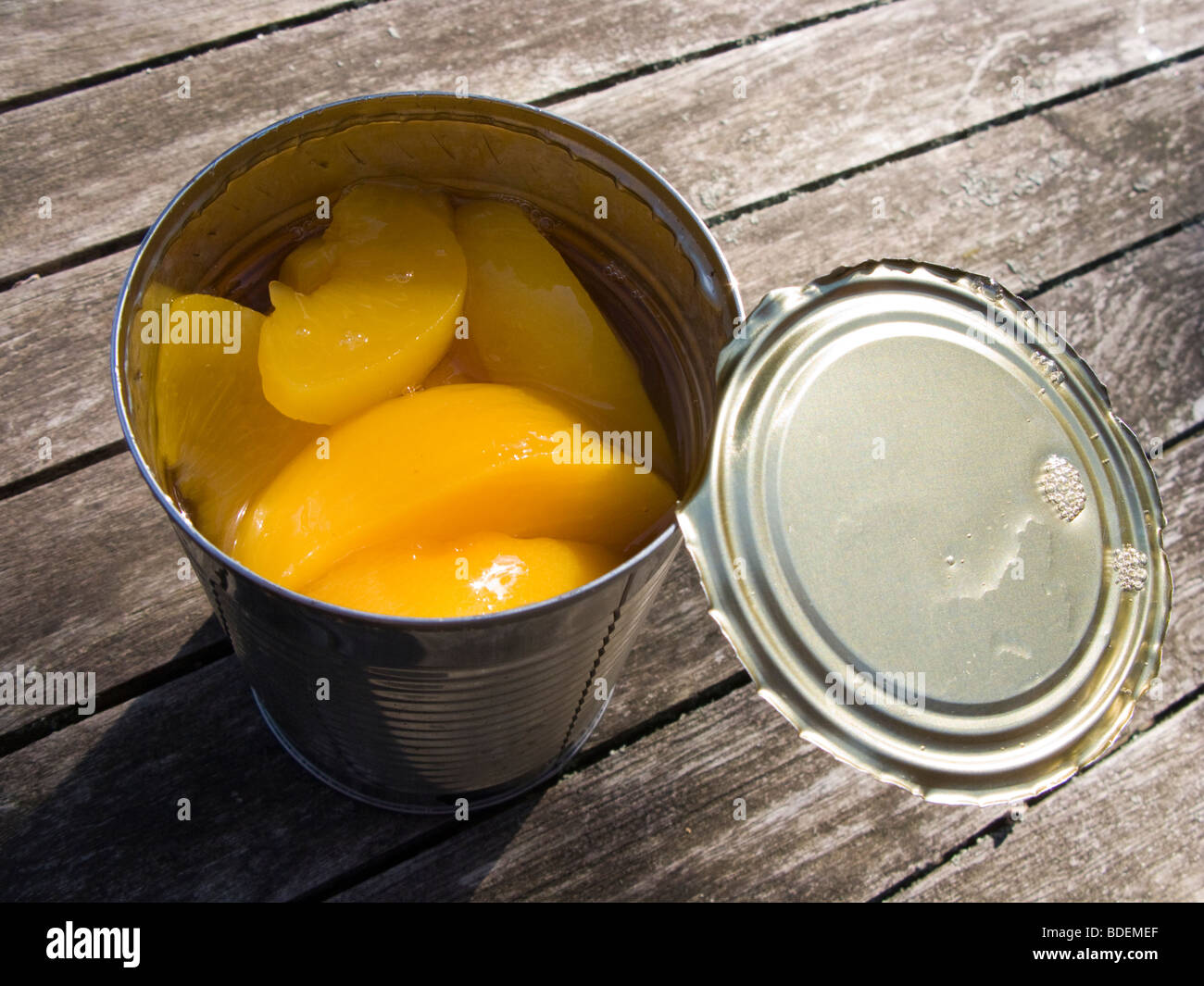 peaches in a tin on wooden table Stock Photo - Alamy