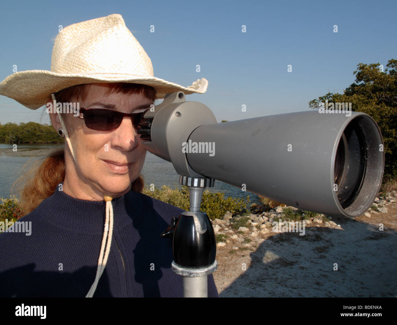a woman looking through a telescope Stock Photo - Alamy