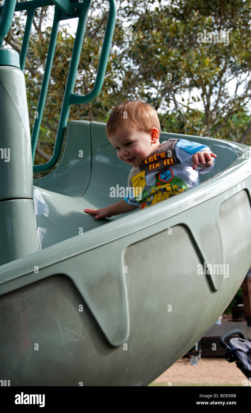 Young boy playing on a slide at a park Stock Photo - Alamy
