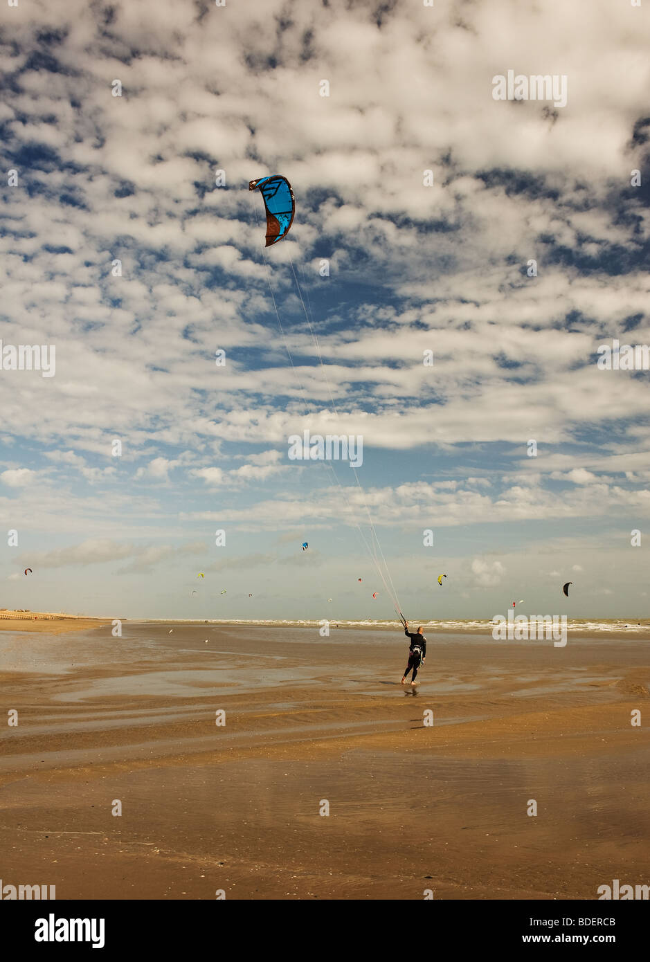 A parasurfer walking towards the sea at Camber Sands in Sussex. Photo ...