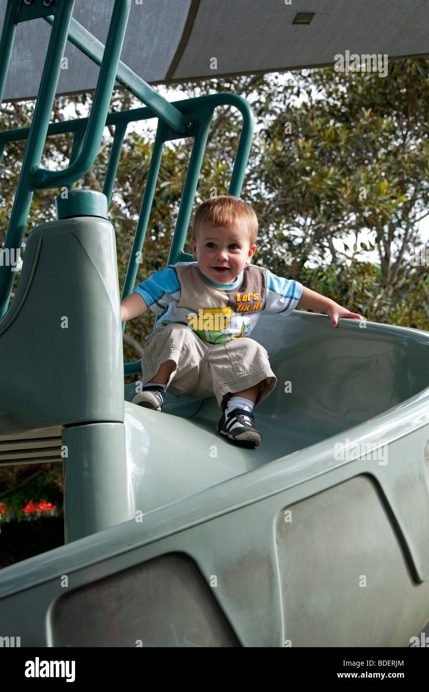 Young boy playing on a slide at a park Stock Photo - Alamy