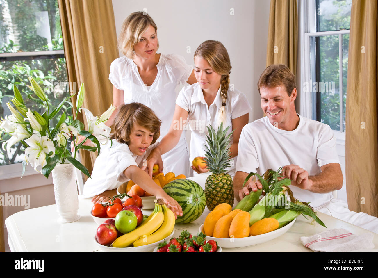 Young family in dining room eating fresh fruits and vegetables Stock ...