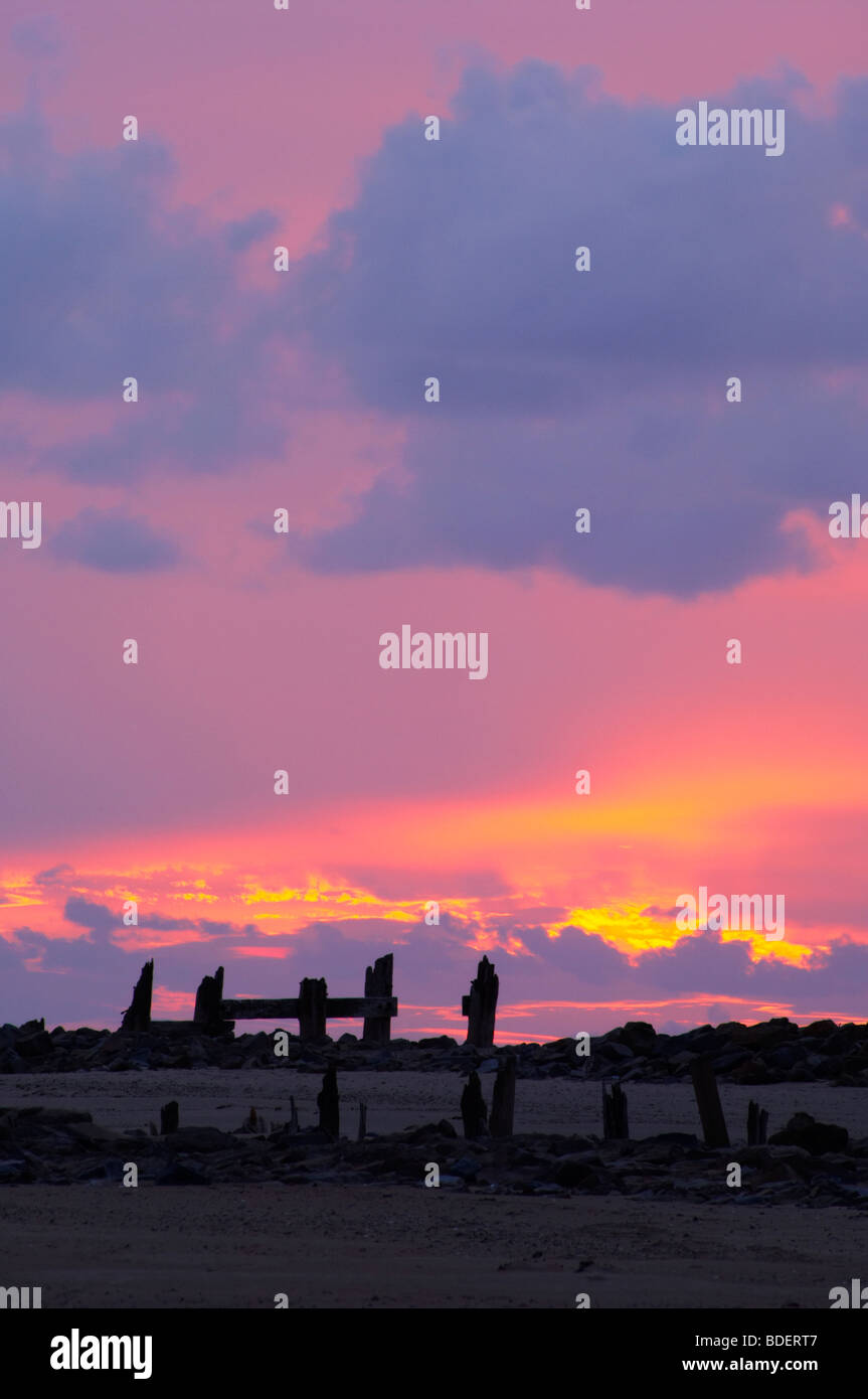 Vivid coloured sunset over timber groynes on the beach at Braunton ...