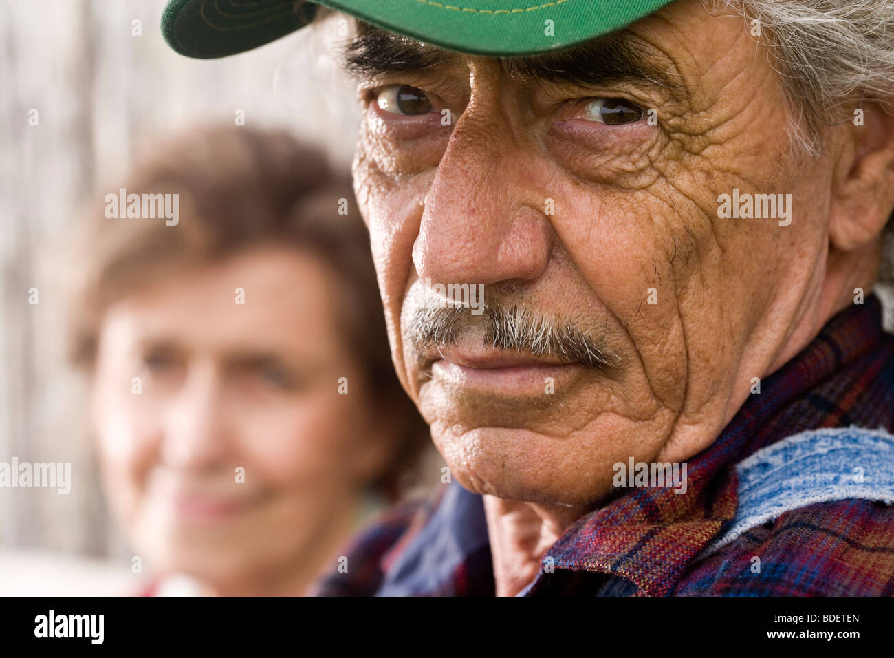 Close-up of senior man wearing green cap Stock Photo - Alamy