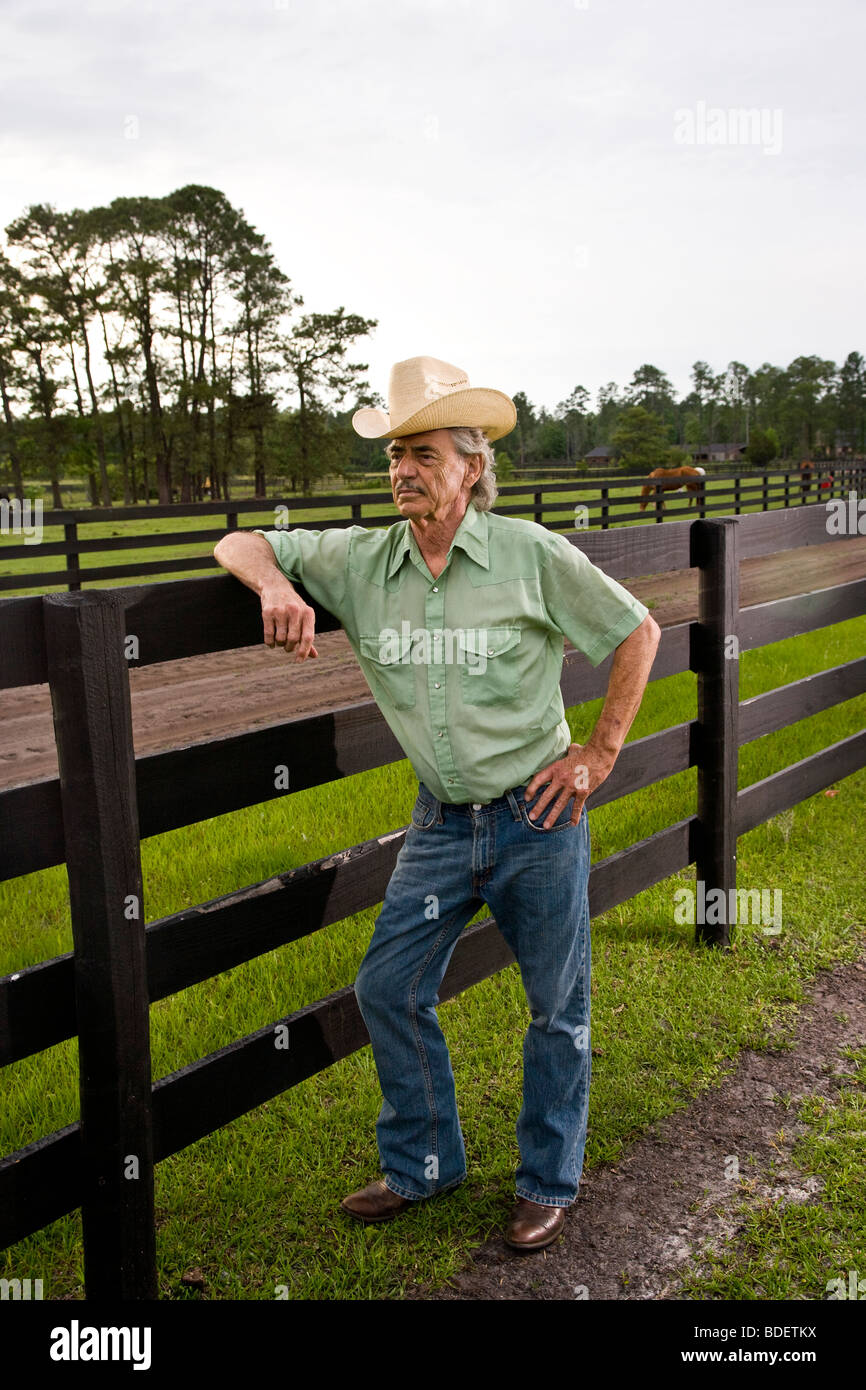 Senior man wearing cowboy hat on ranch leaning on fence Stock Photo - Alamy
