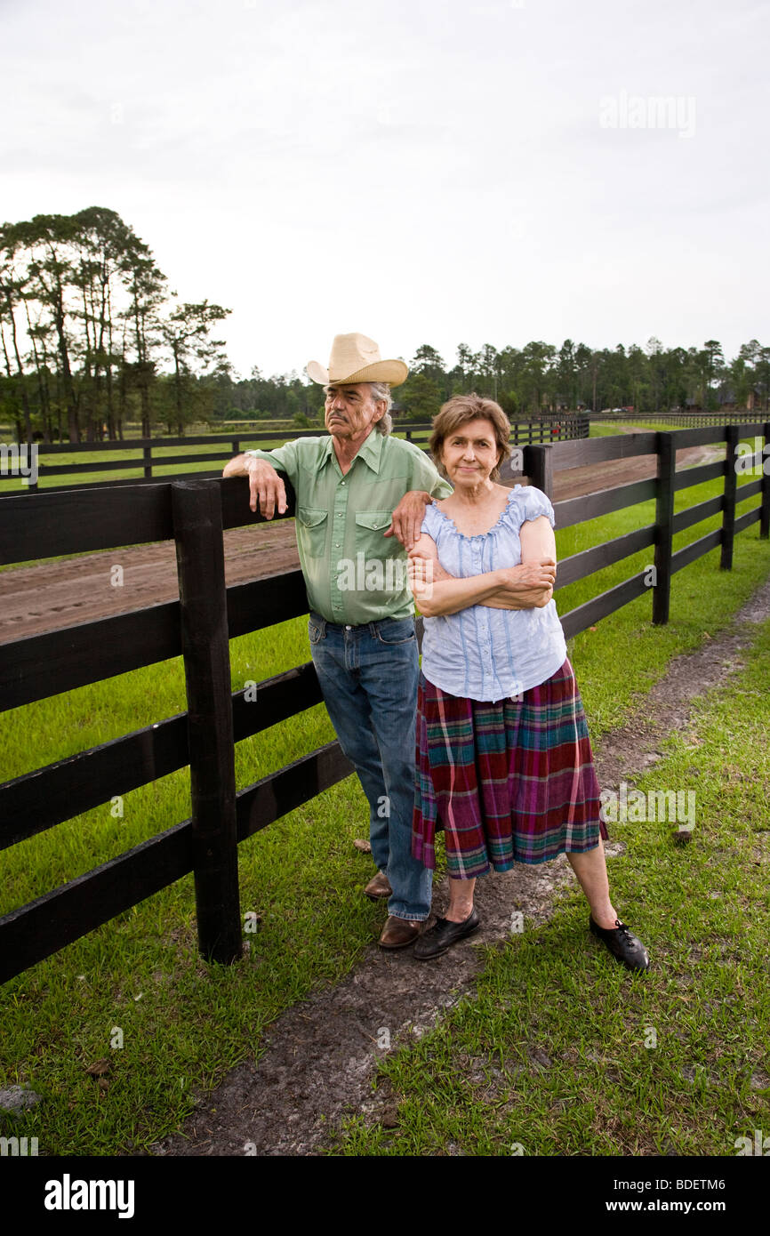 Senior couple standing on ranch near fence Stock Photo - Alamy