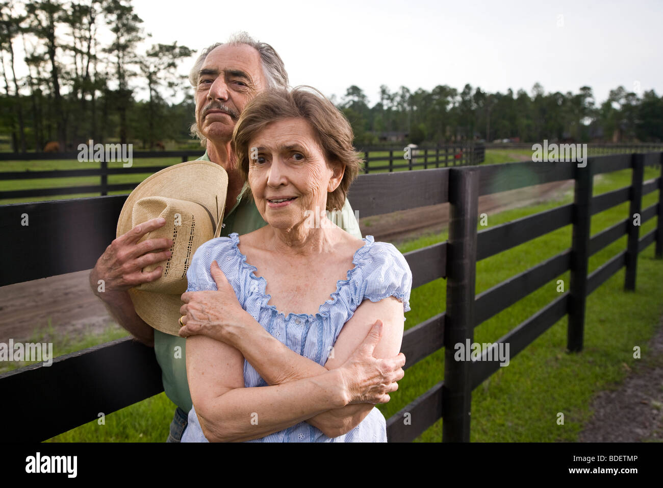 Senior couple standing on ranch near fence Stock Photo - Alamy
