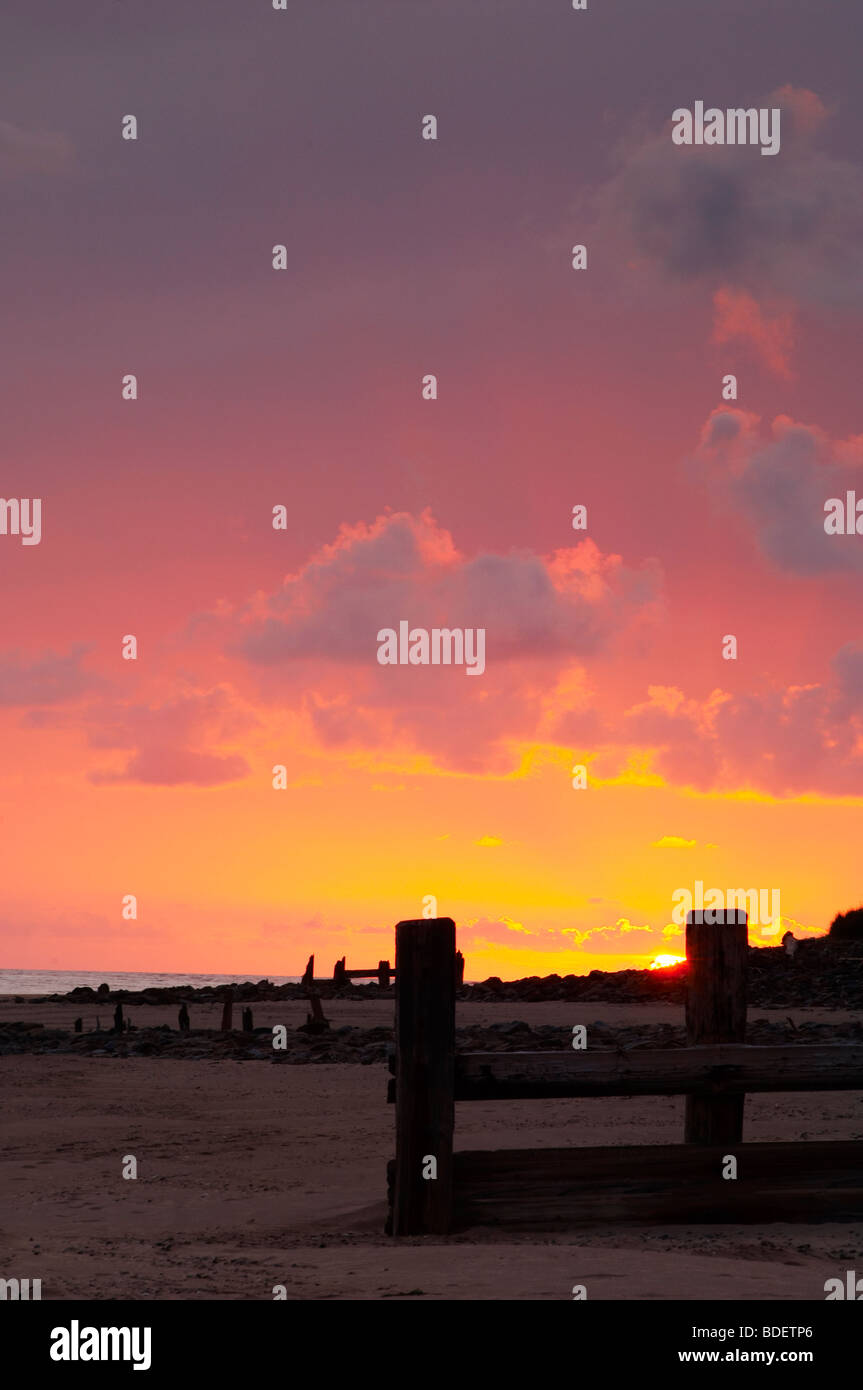 Vivid coloured sunset over timber groynes on the beach at Braunton ...