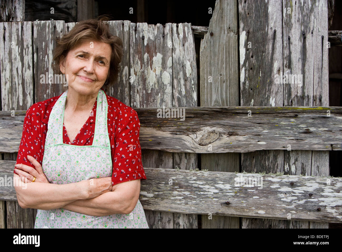 Senior woman by weathered barn Stock Photo - Alamy