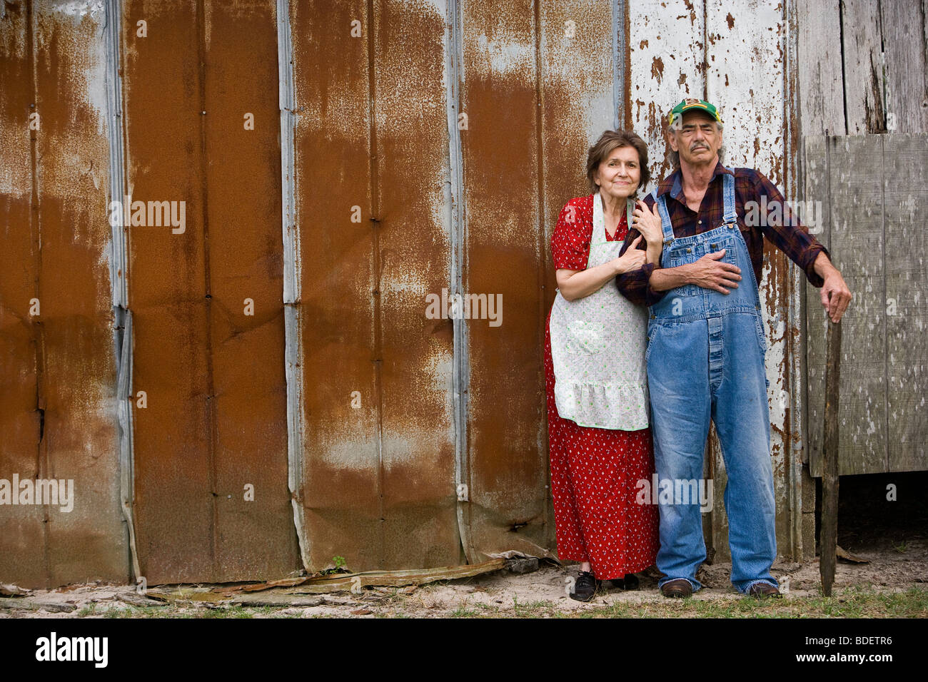 Senior couple standing outside weathered barn Stock Photo - Alamy