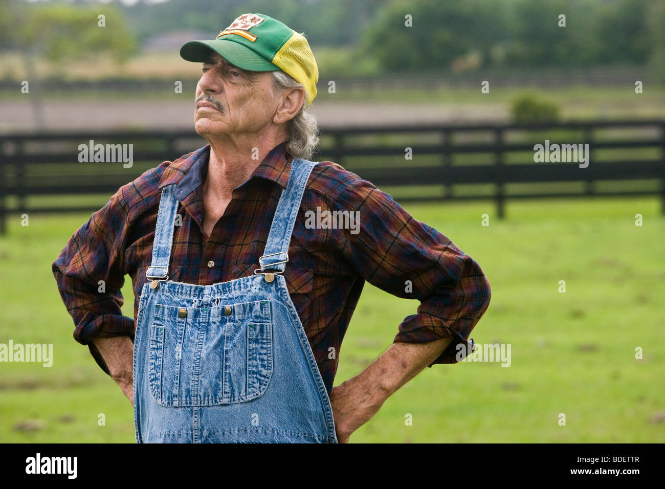 Ranch worker standing in green field Stock Photo - Alamy