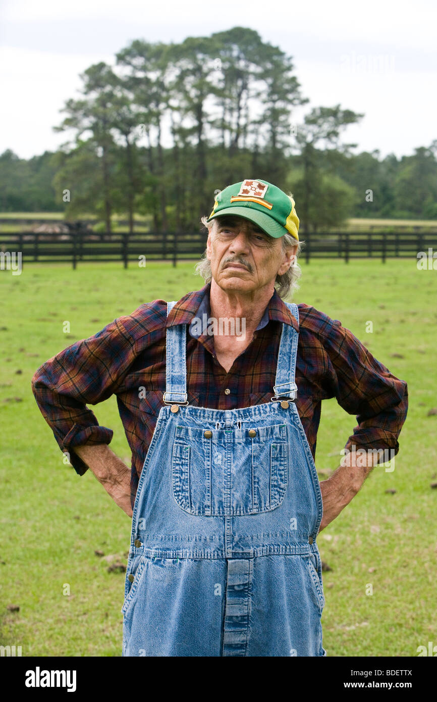 Ranch worker standing in green field Stock Photo - Alamy