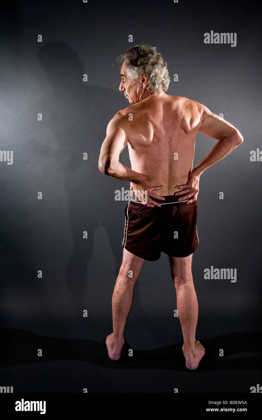 Rear view of senior man with hands on lower back, studio shot Stock ...