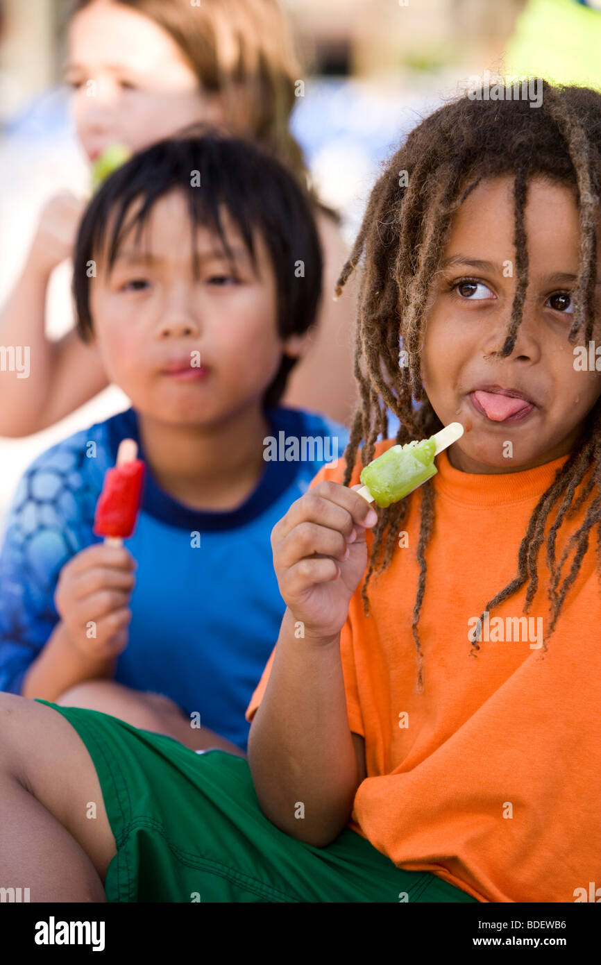 Multi-ethnic children eating popsicles at water park Stock Photo - Alamy