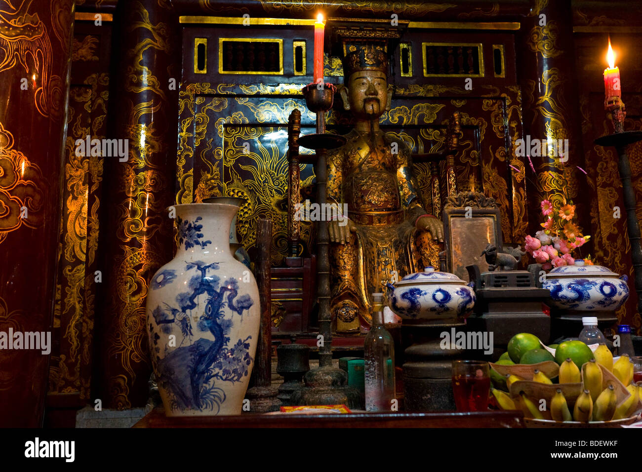 Richly-decorated interior of a temple with porcelain vases and a gold ...