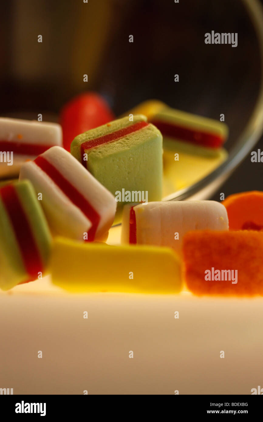 Brightly coloured fruit allsorts sweets candy against dark background ...