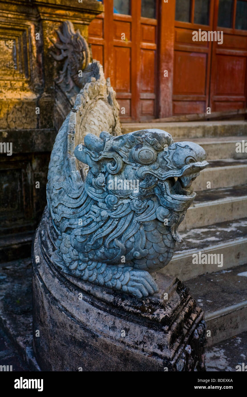 A stone dragon guards the doorway of a palace building in Hue, Vietnam ...