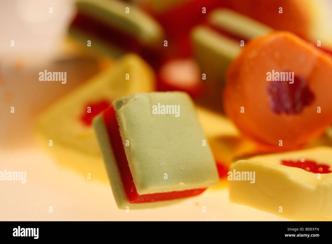 Brightly coloured sweets scattered on white background Stock Photo - Alamy