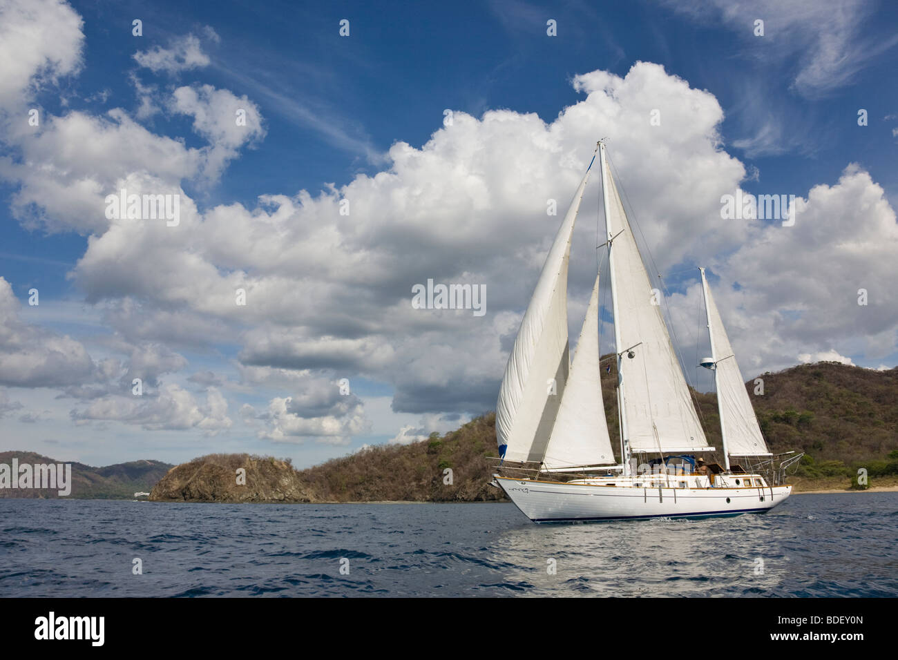 Ketch rig sailboat cruising along the shoreline in the Papagayo Bay ...