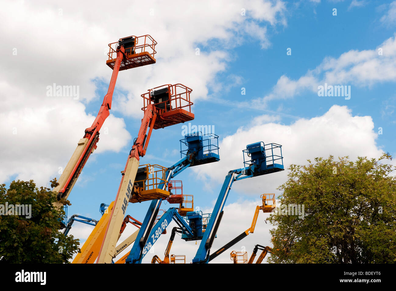 Hydraulic platforms known as Cherry Pickers, lined up against the sky ...