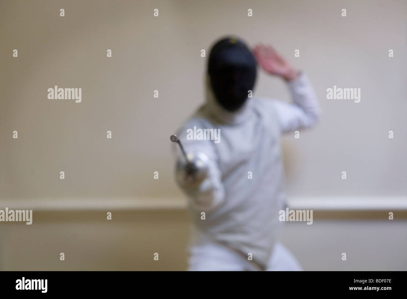 A masked fencer pointing his foil at the camera Stock Photo - Alamy