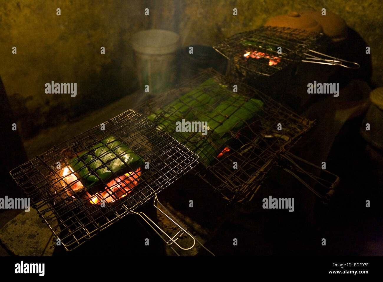 Packages of fish in banana leaves cooking on a brazier Stock Photo - Alamy
