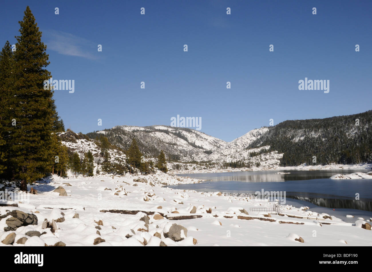 Snowy place of fun, families frolic and sledge near icy lake in soft ...