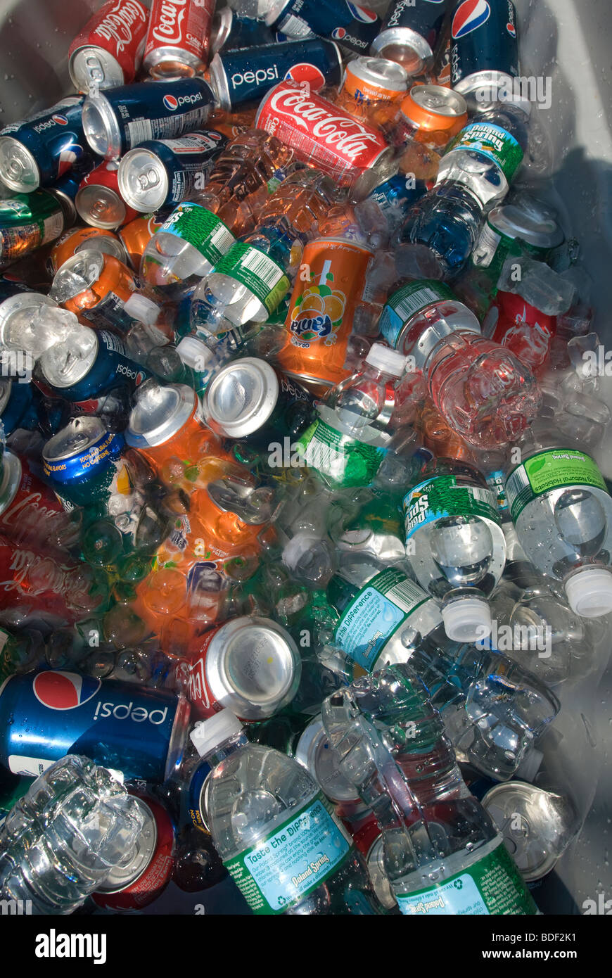 Cans of ice cold soda and water in a container of ice are sold by an ...