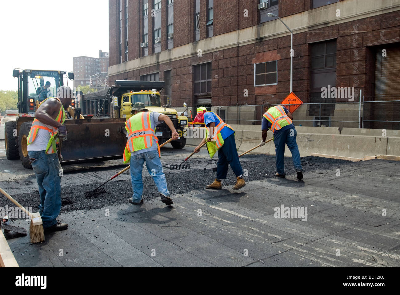 Workers from the NYC Dept. of Transportation pave a repair to the FDR ...
