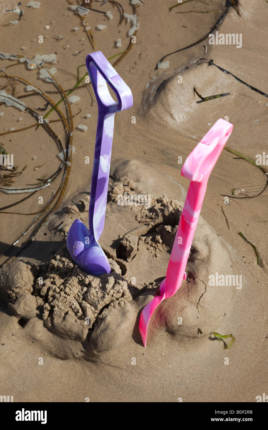 Spades / shovels stuck in sand on beach Stock Photo - Alamy