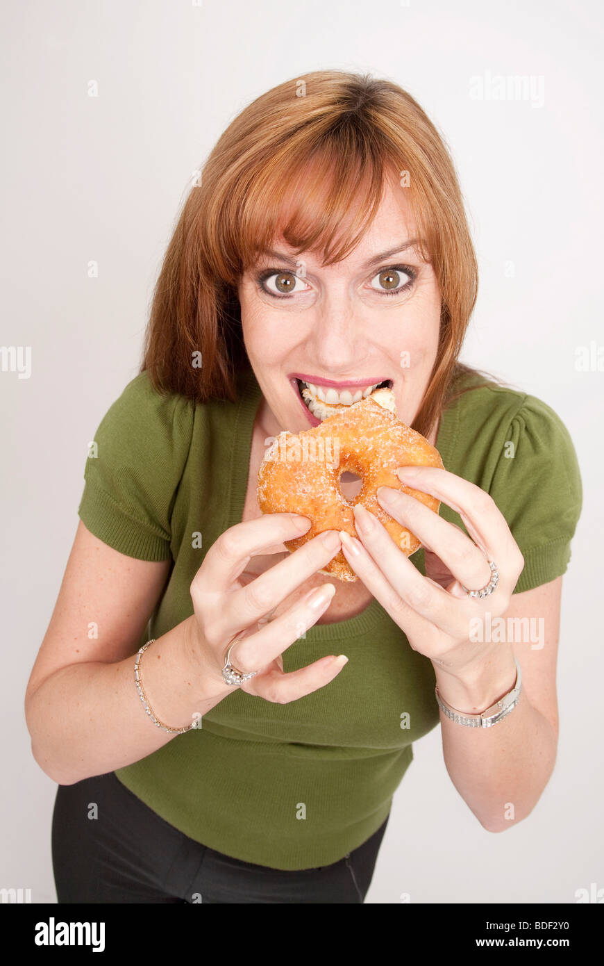 Woman eating a doughnut Stock Photo - Alamy