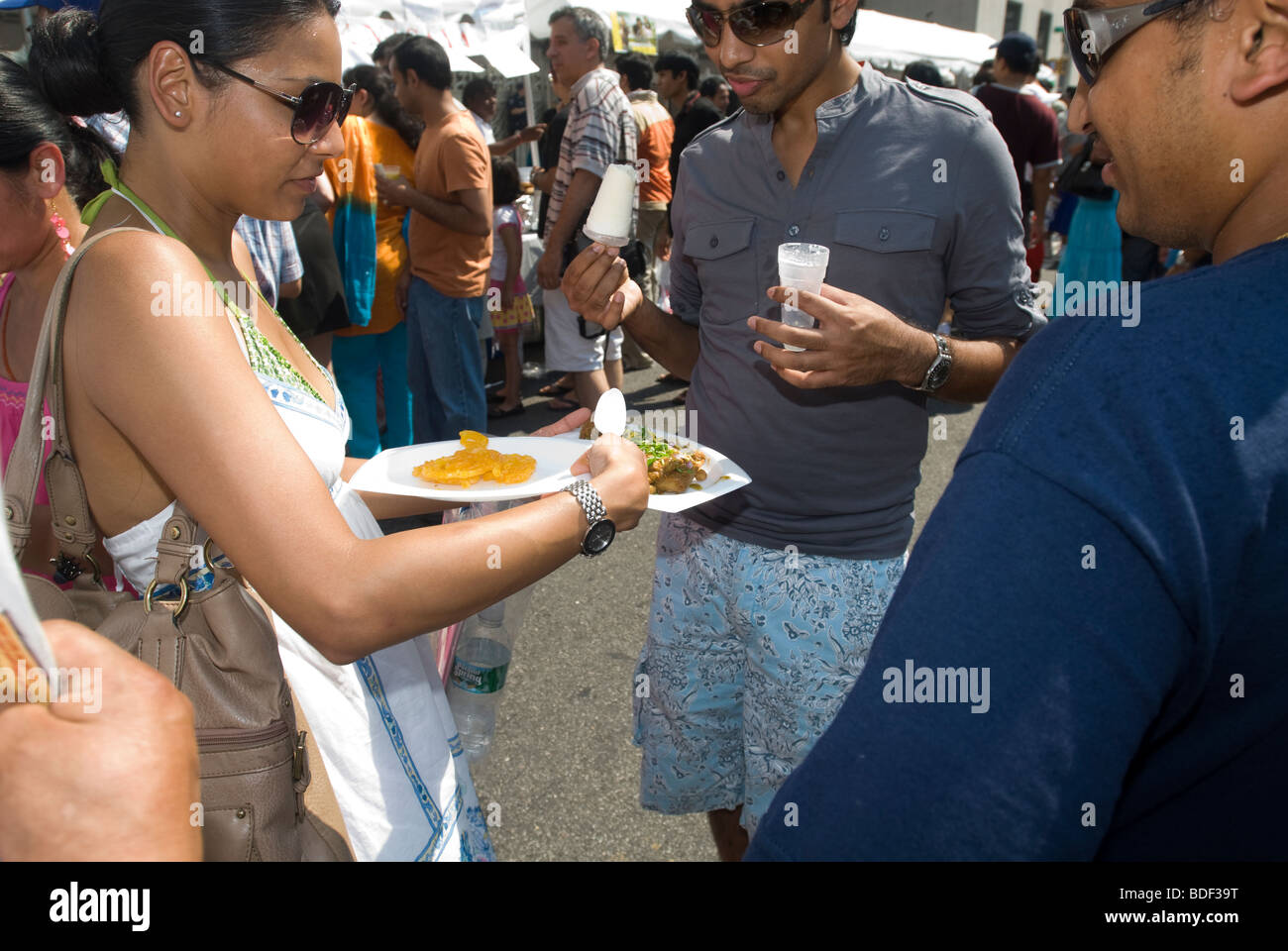 Parade goers enjoy Indian street food at a street fair following the ...