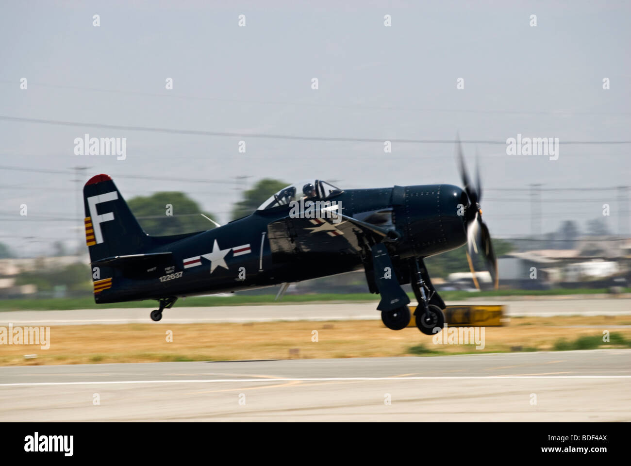 A Grumman F8F Bearcat as it just lifts off the runway at an air show ...