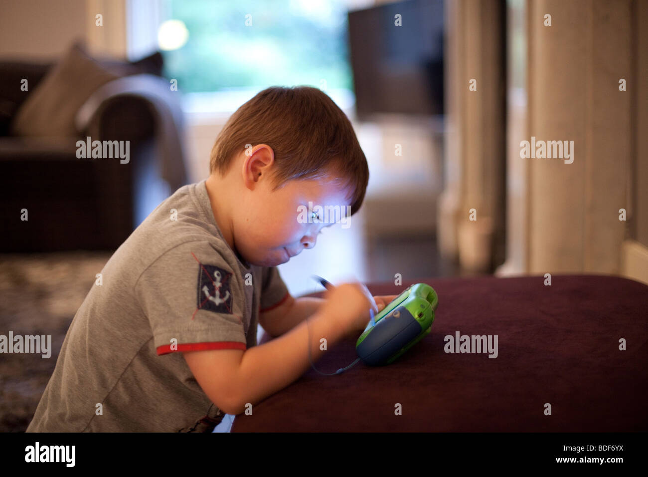A young boy using a small hand held computer Stock Photo - Alamy
