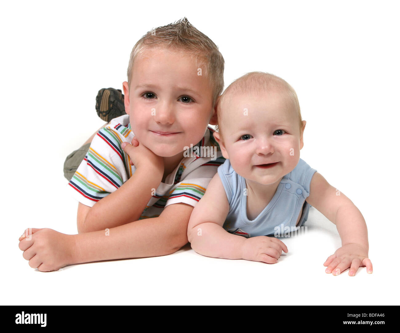 Young Brothers Lying on Their Stomachs on White Background Stock Photo ...