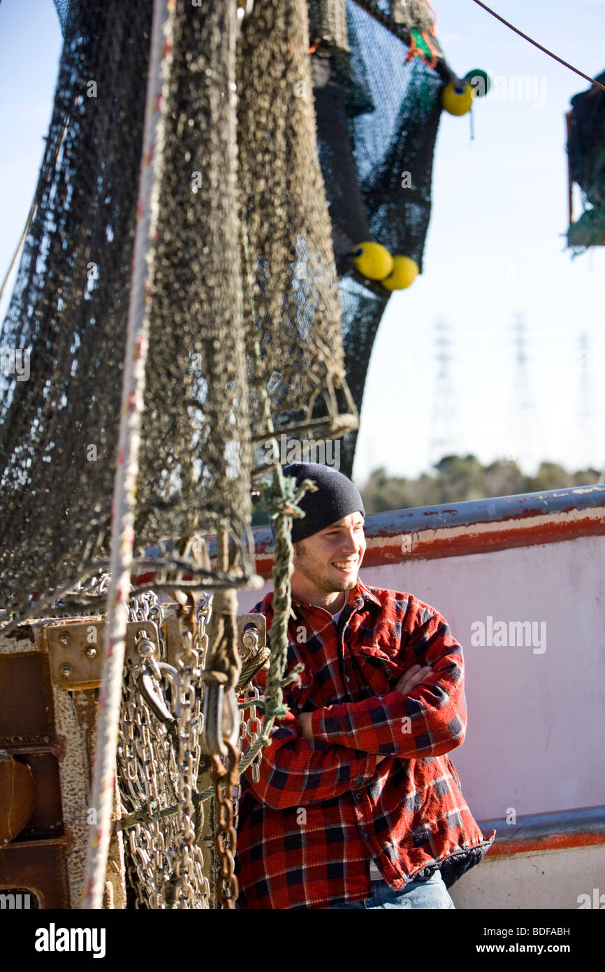 Young fisherman in plaid shirt standing near fishing boat Stock Photo ...
