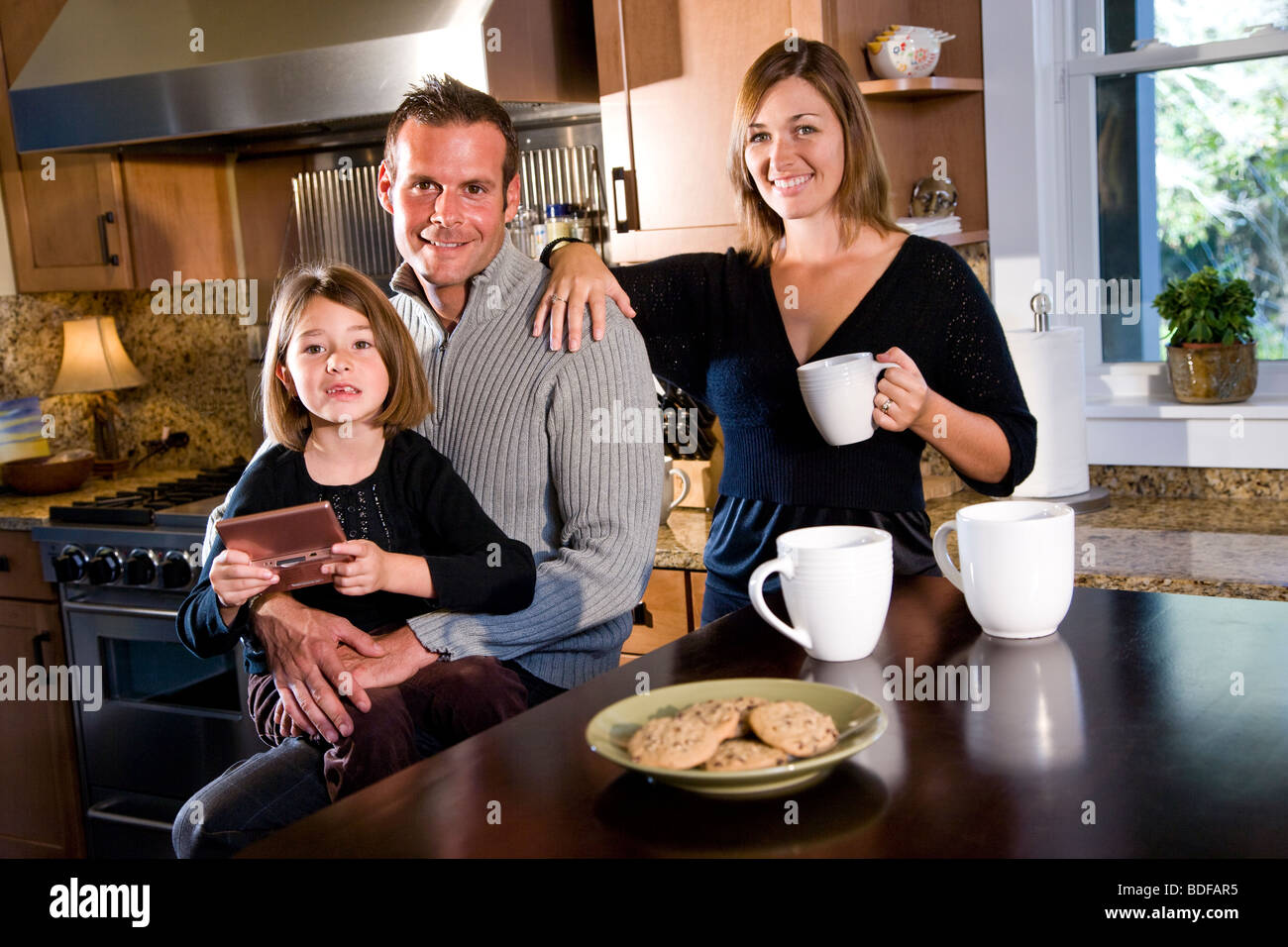 Family enjoying snack in kitchen Stock Photo - Alamy