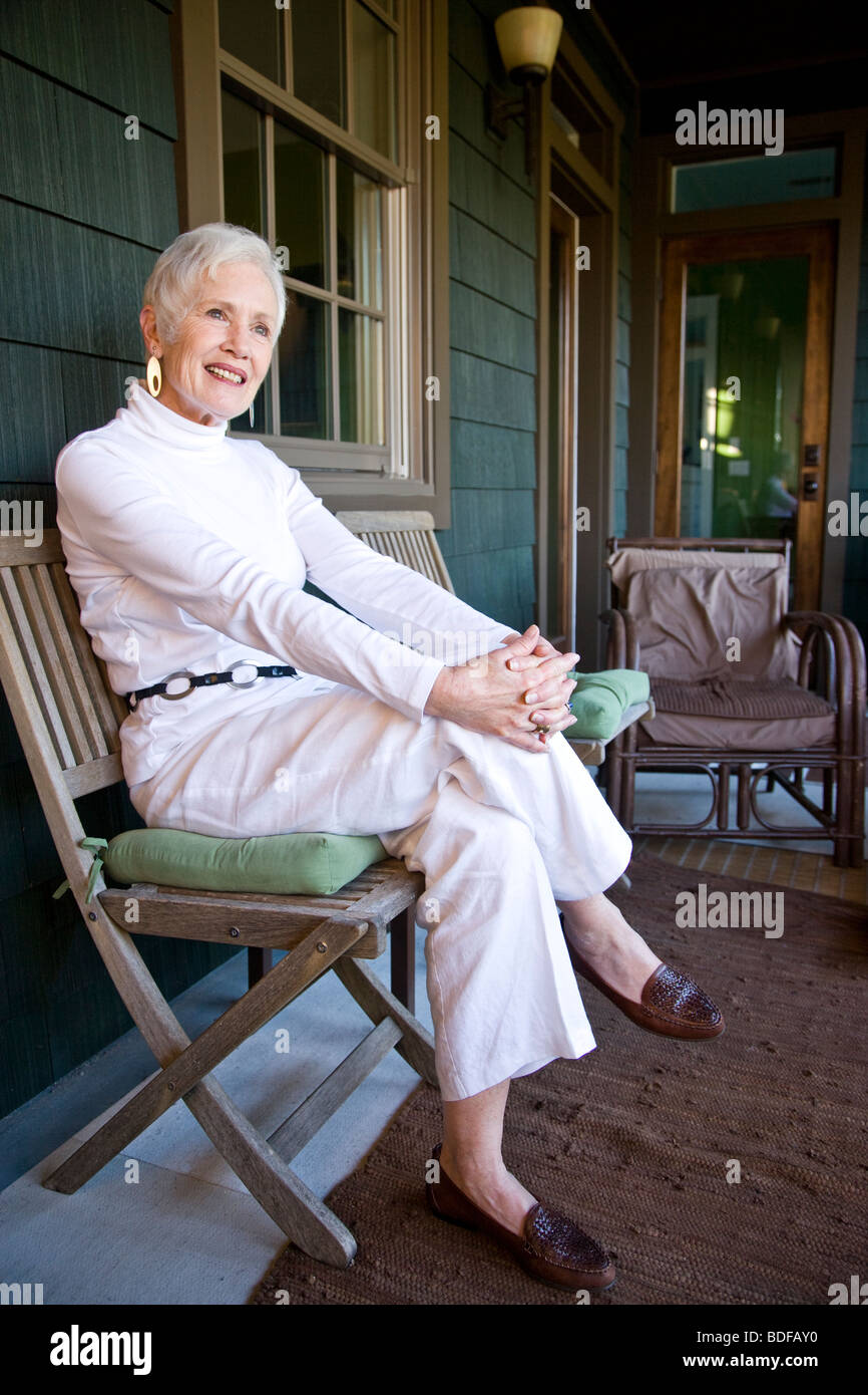 Senior woman sitting in chair on front porch Stock Photo - Alamy