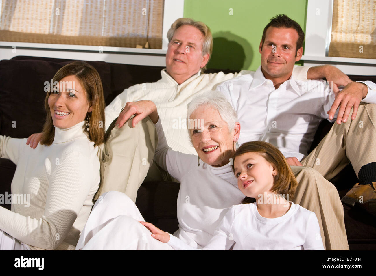 Multi-generational family sitting in living room at home Stock Photo ...