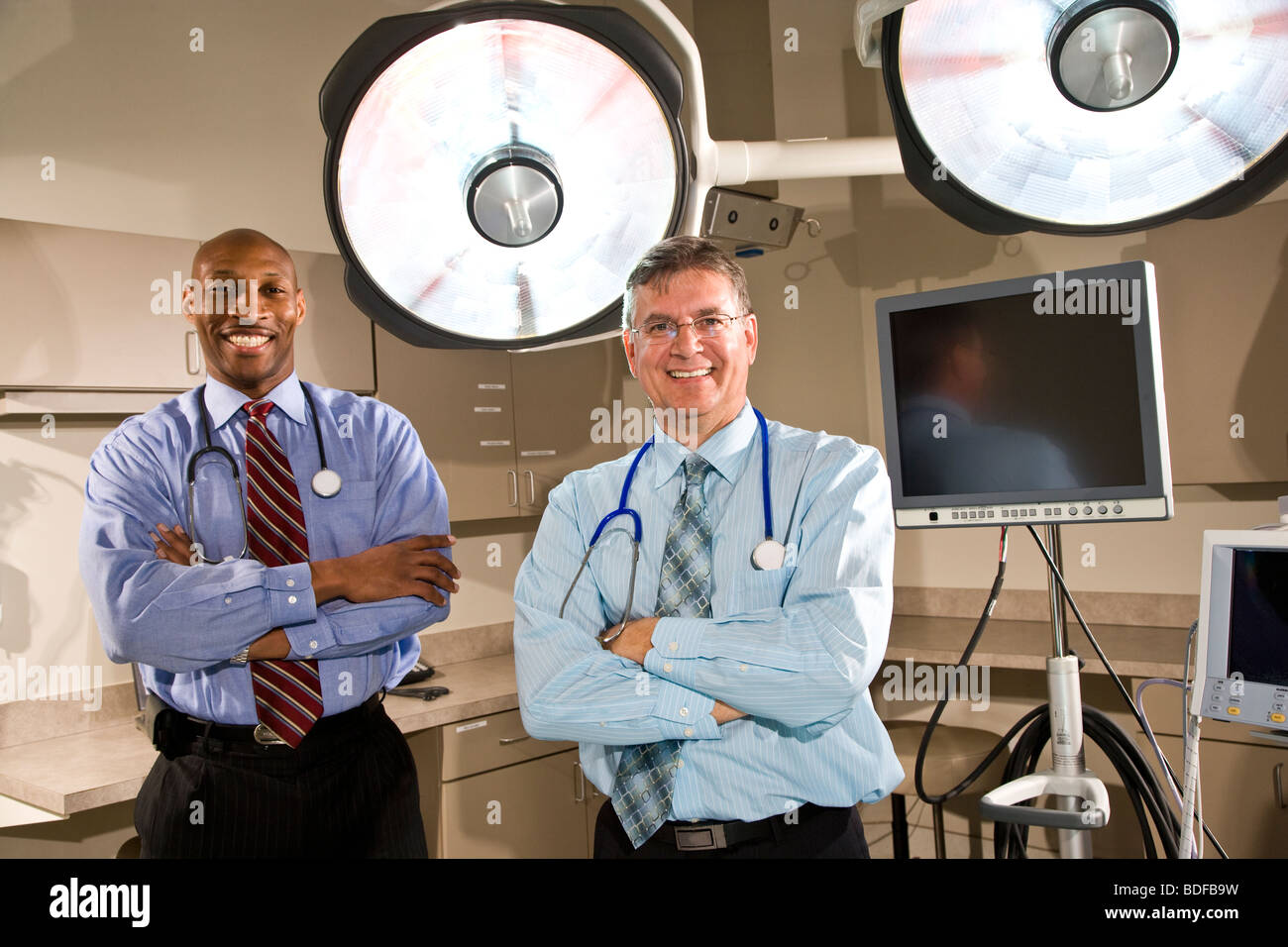 Portrait of multi-ethnic doctors in hospital room with surgical lights ...