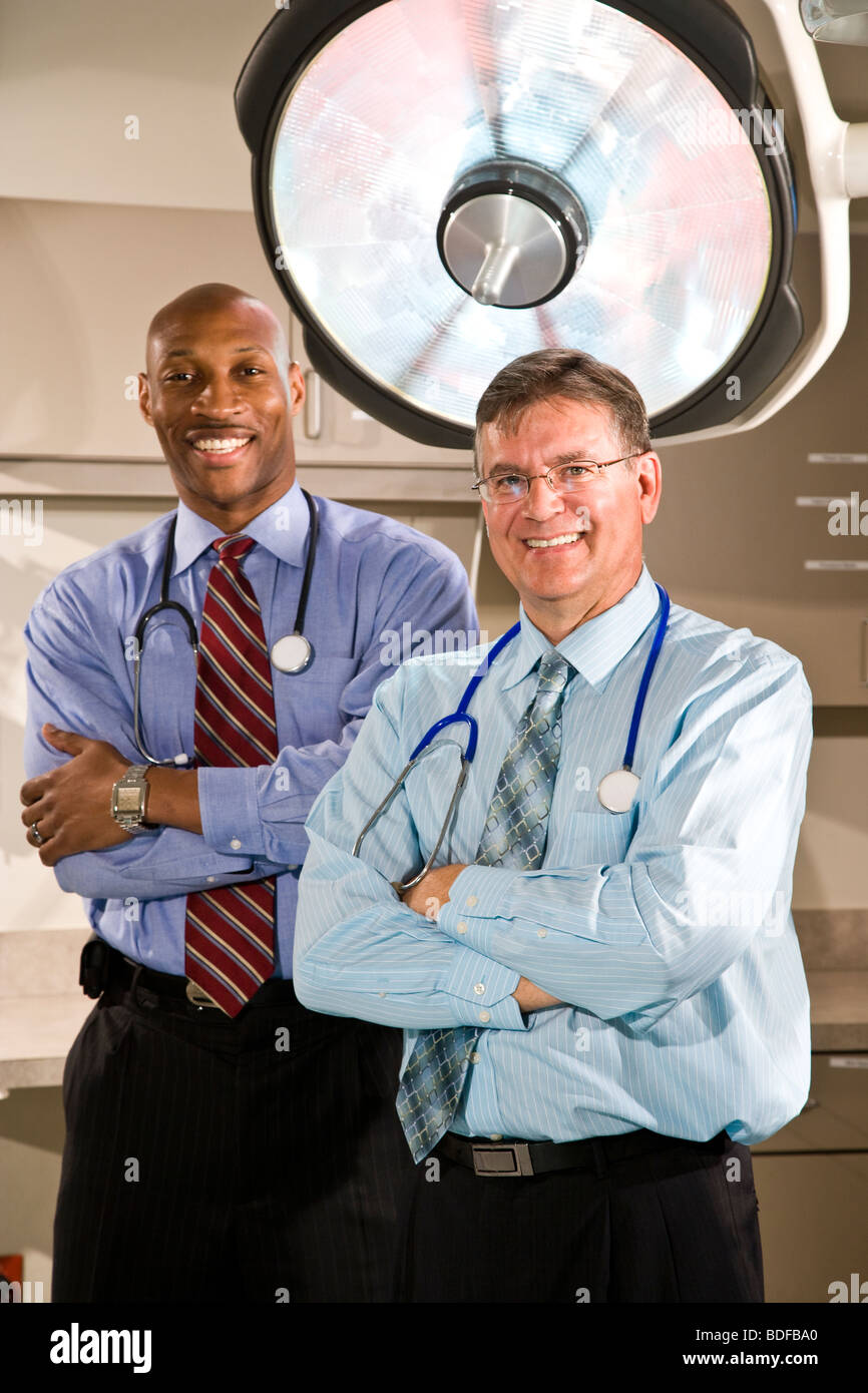 Portrait of multi-ethnic doctors in hospital room with surgical lights ...