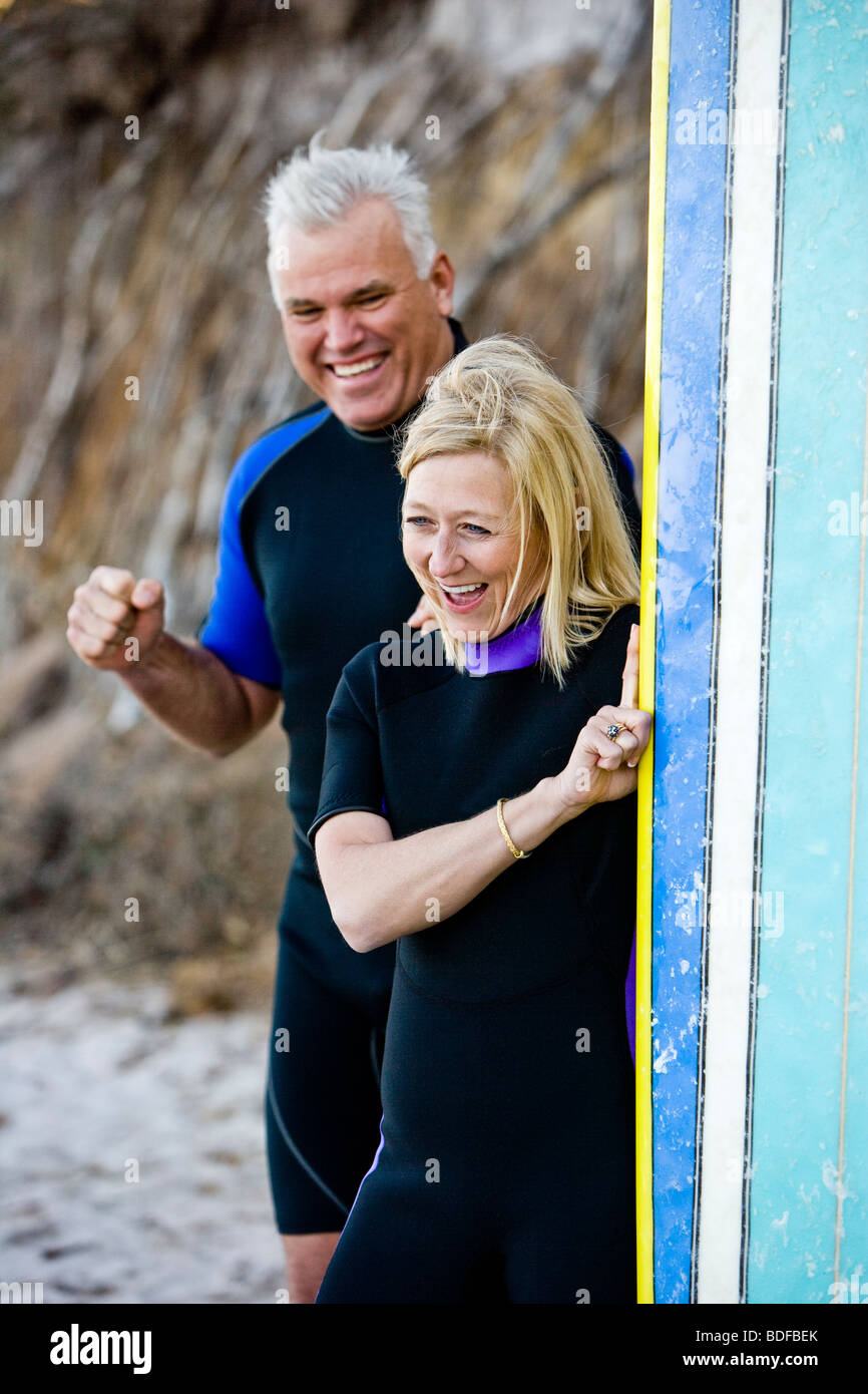 Middle-aged surfer couple on beach with surfboard Stock Photo - Alamy