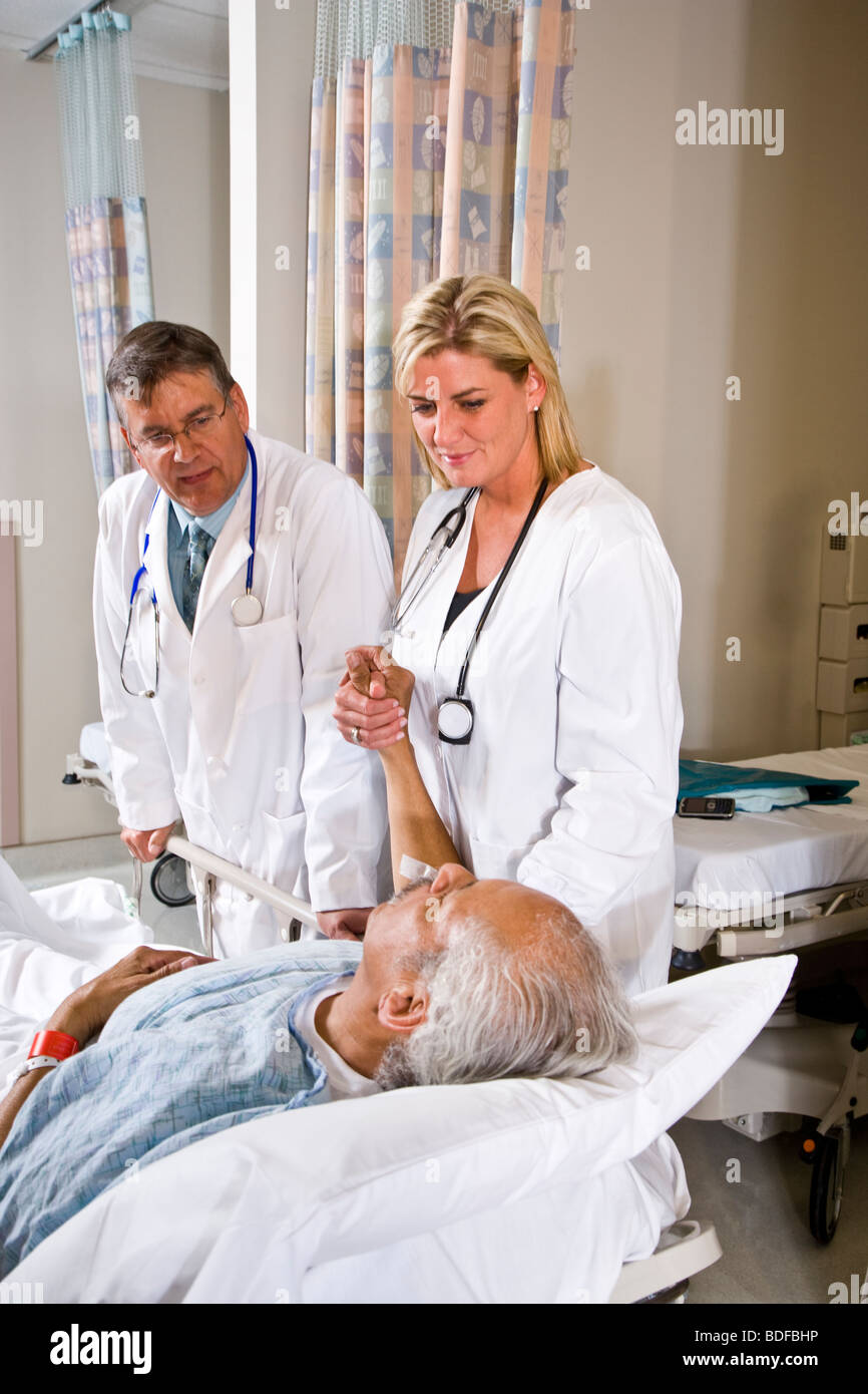 Doctors in hospital recovery room with patient Stock Photo - Alamy