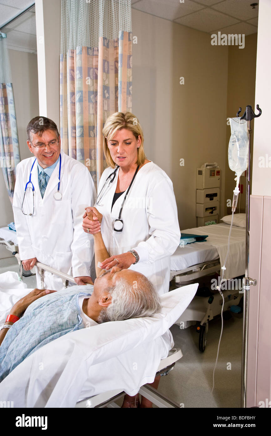 Doctors in hospital recovery room with patient Stock Photo - Alamy