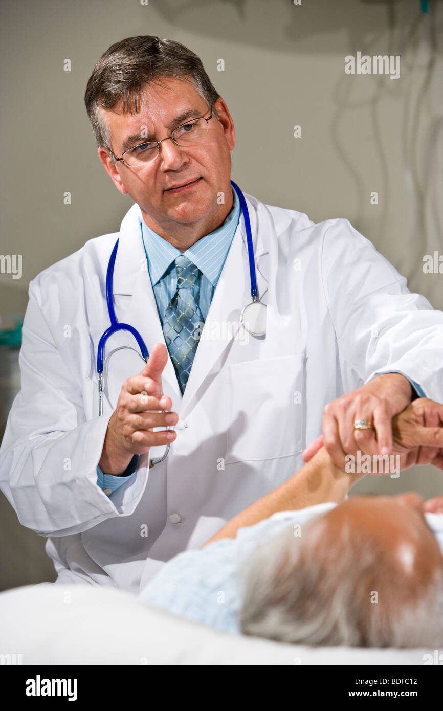 Doctor taking pulse of patient in bed Stock Photo - Alamy