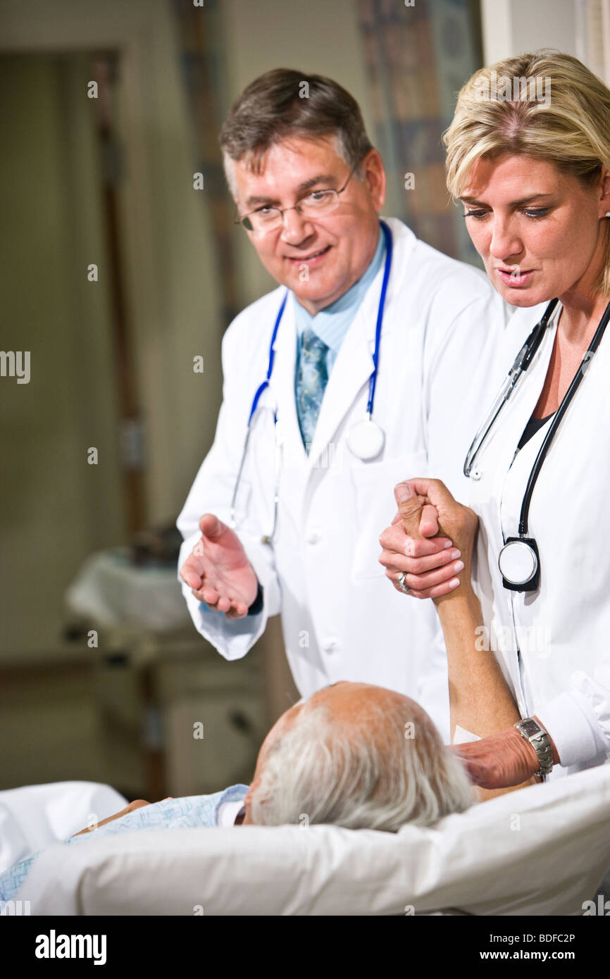 Doctors with patient in hospital room Stock Photo - Alamy